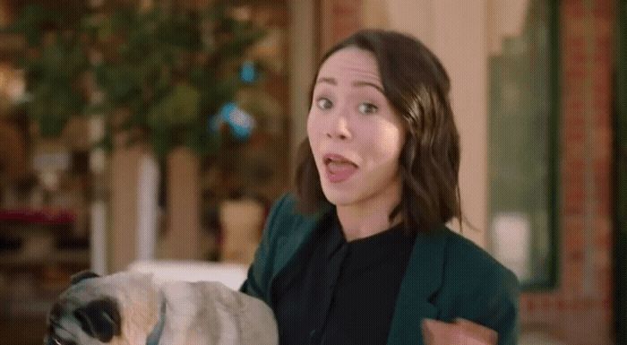 A woman holding a pug dog in her arms | Kive